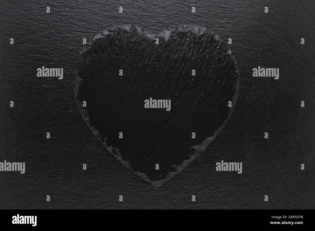 Black heart slate plate on black background Stock Photo - Alamy