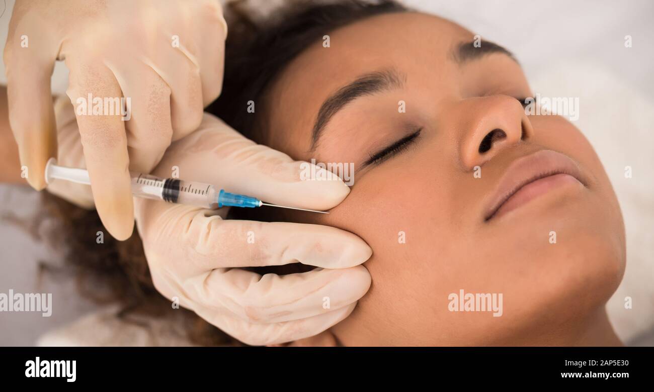 Aesthetic cosmetology. Black woman getting beauty facial injection ...