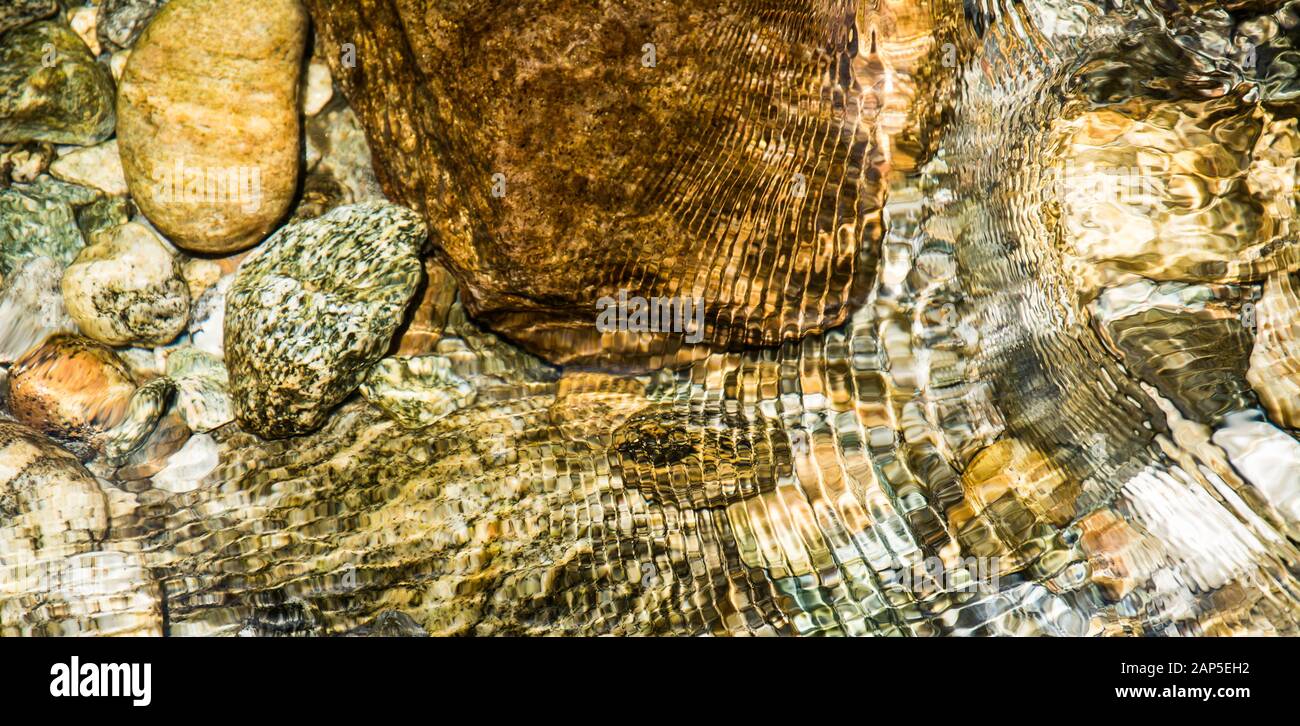 water surface with small ripples of a river with stones Stock Photo - Alamy