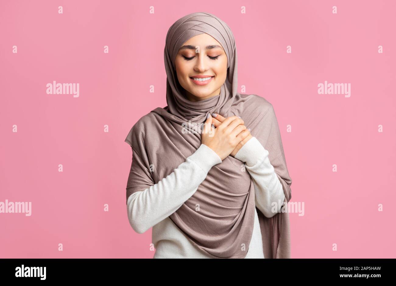 Grateful muslim girl keeping both palms on chest, expressing ...