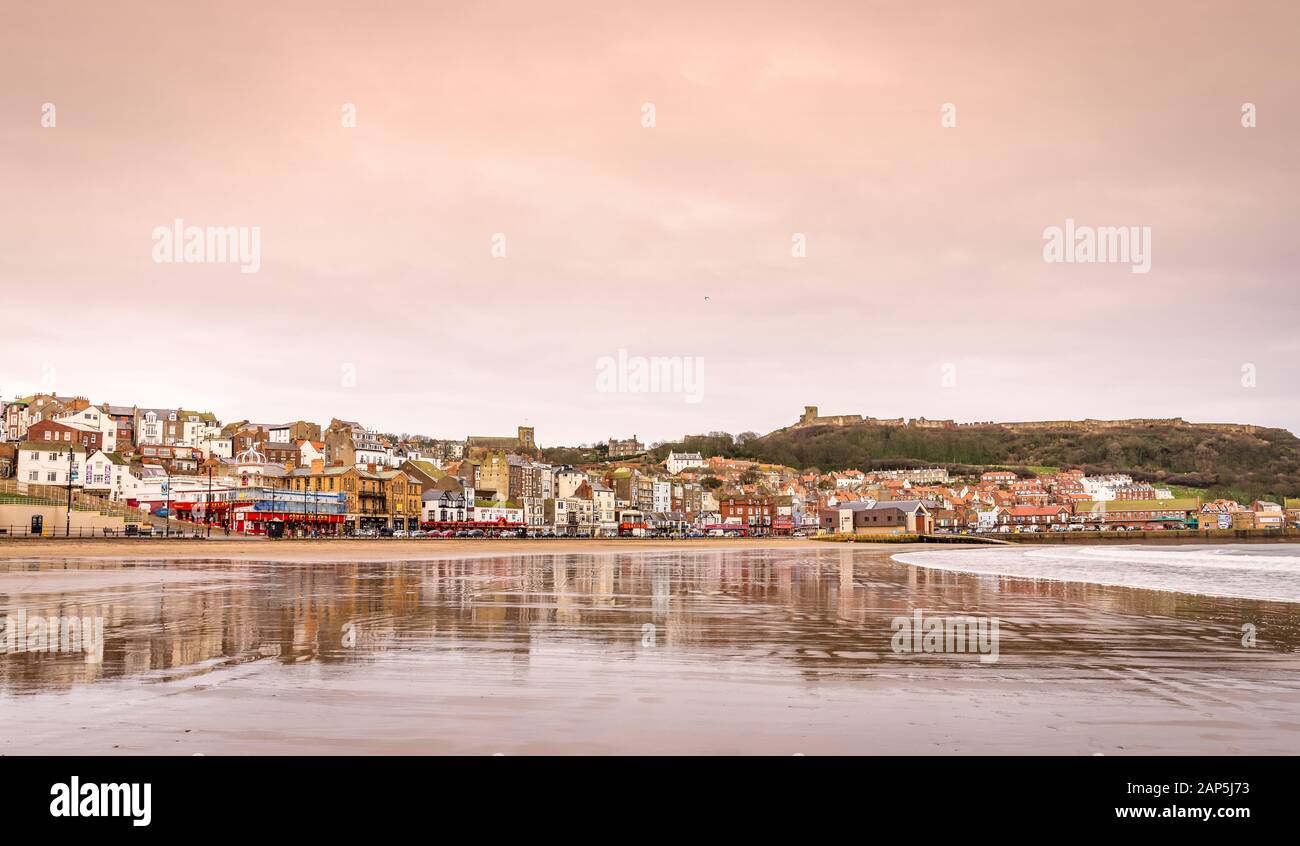 The beach and town of Scarborough. The seafront buildings are reflected ...