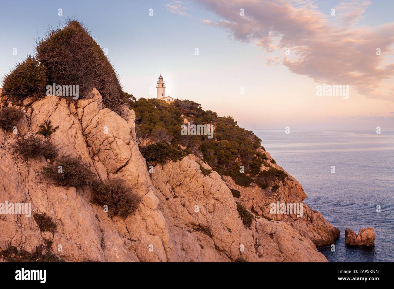 Capdepera lighthouse, sunset with soft light,bay with rocks and trees ...