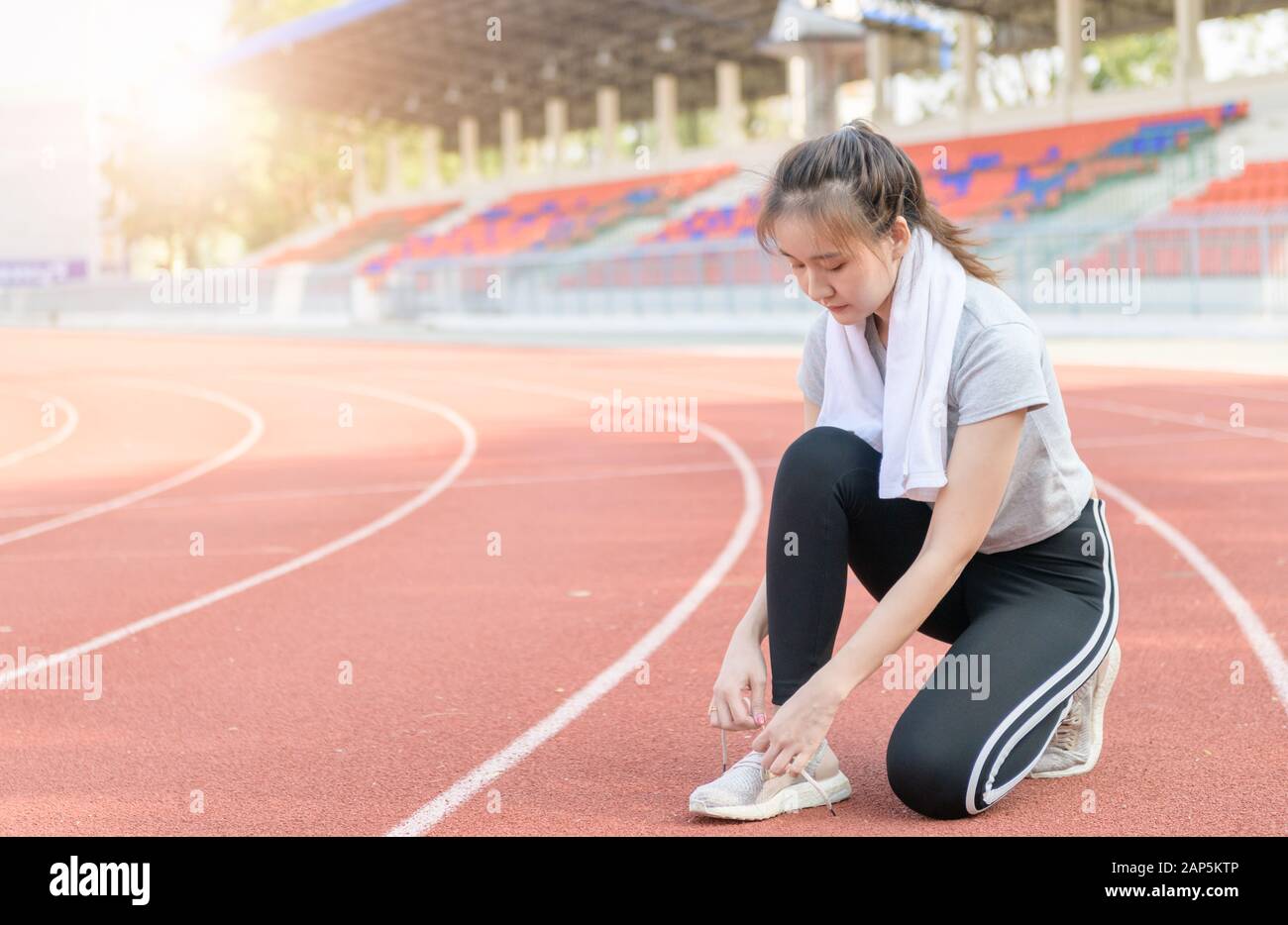Athlete girl trying running shoes getting ready for jogging on track at ...