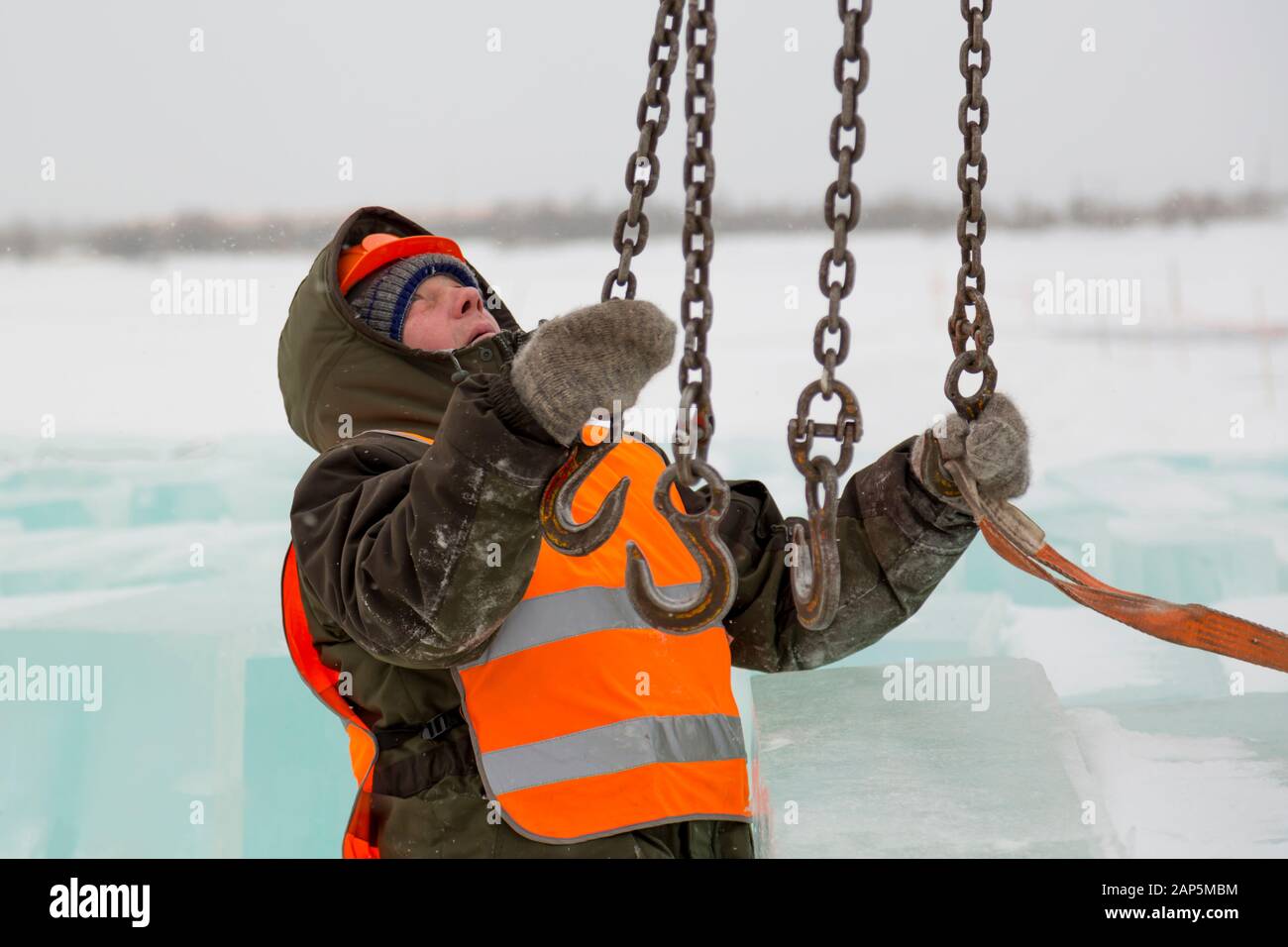 Slinger in orange helmet on shipment of ice blocks Stock Photo - Alamy