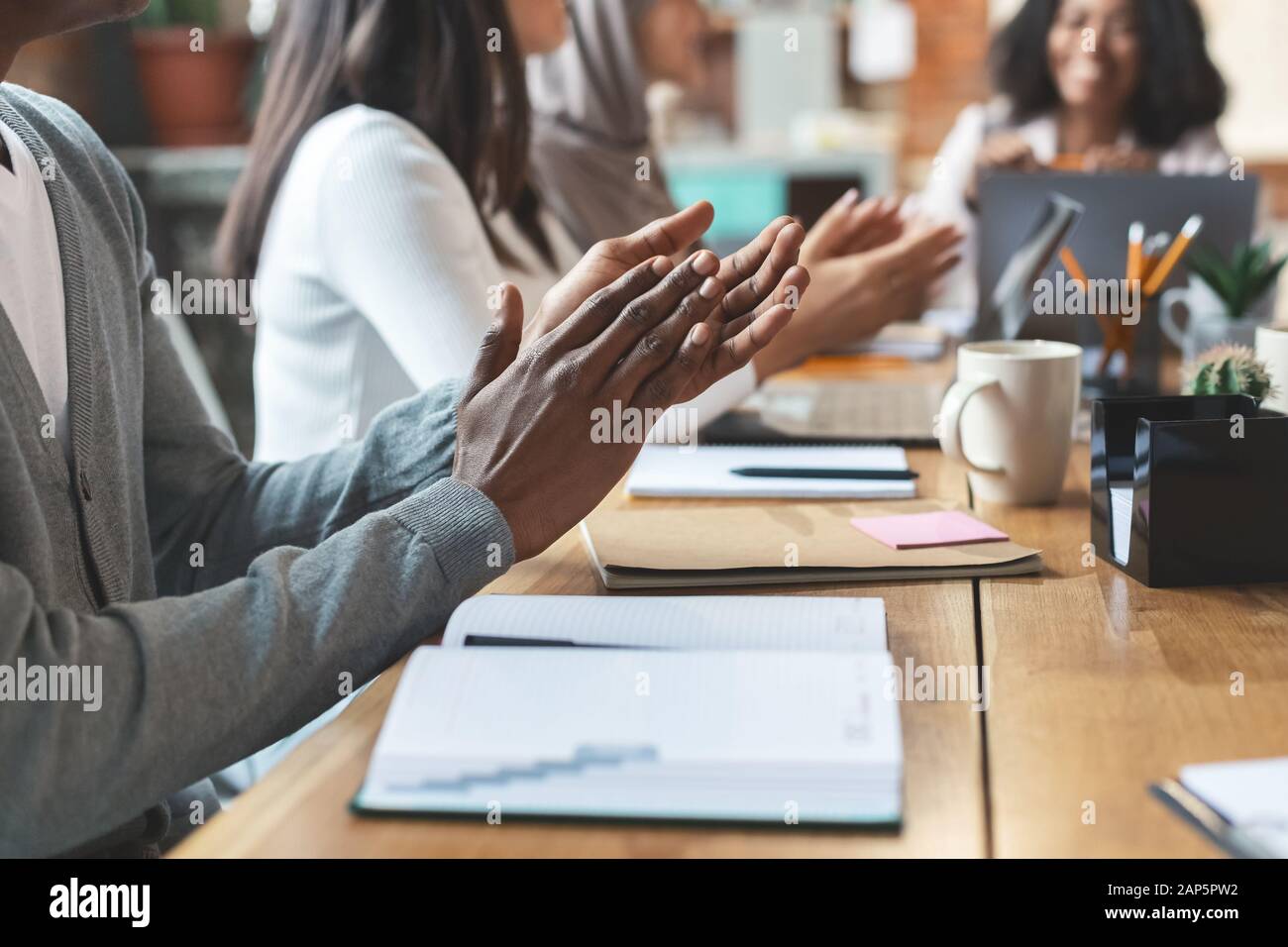 Close up of international team of employees clapping hands Stock Photo ...