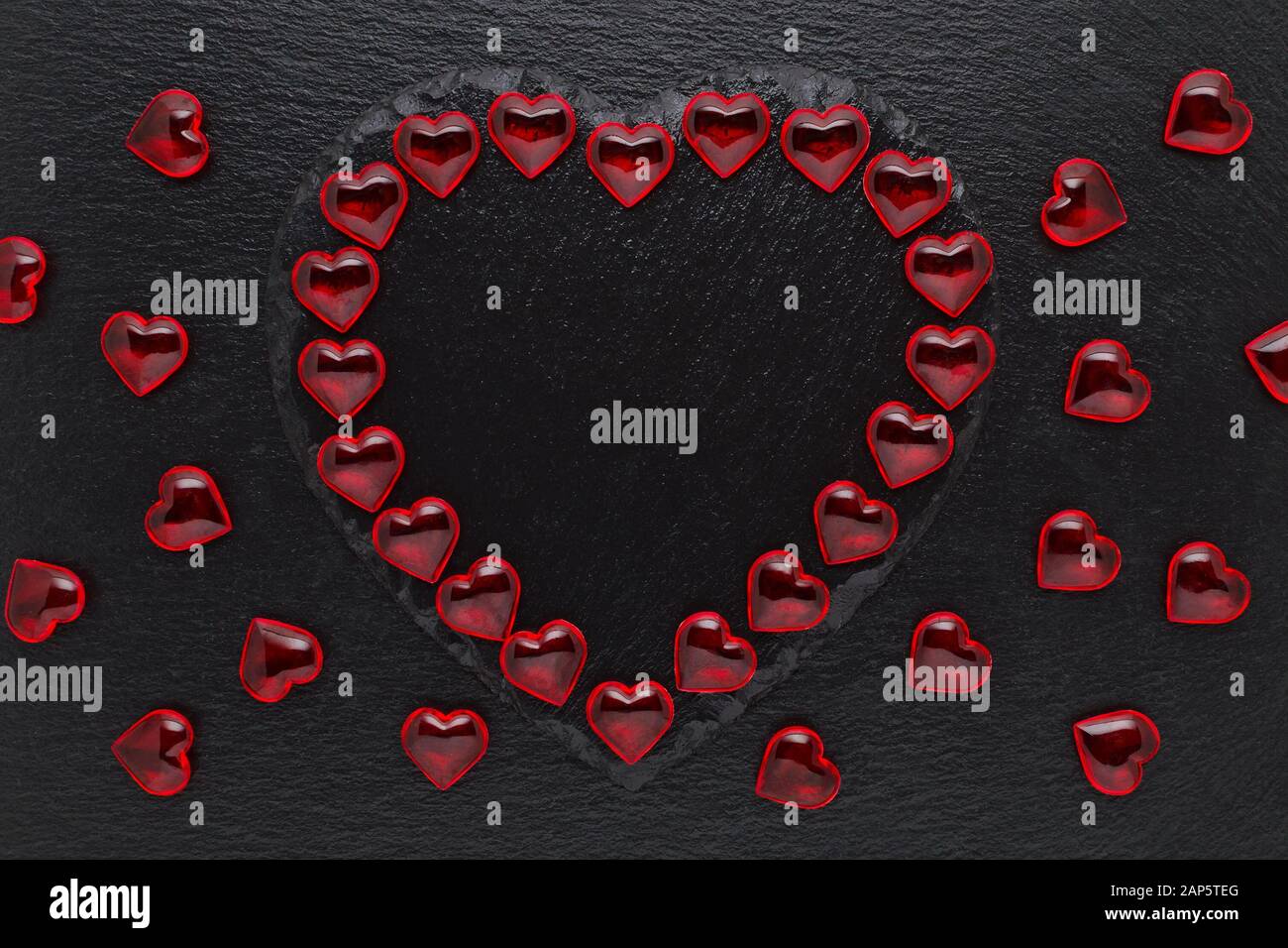 Black slate plate with red hearts on black background Stock Photo - Alamy