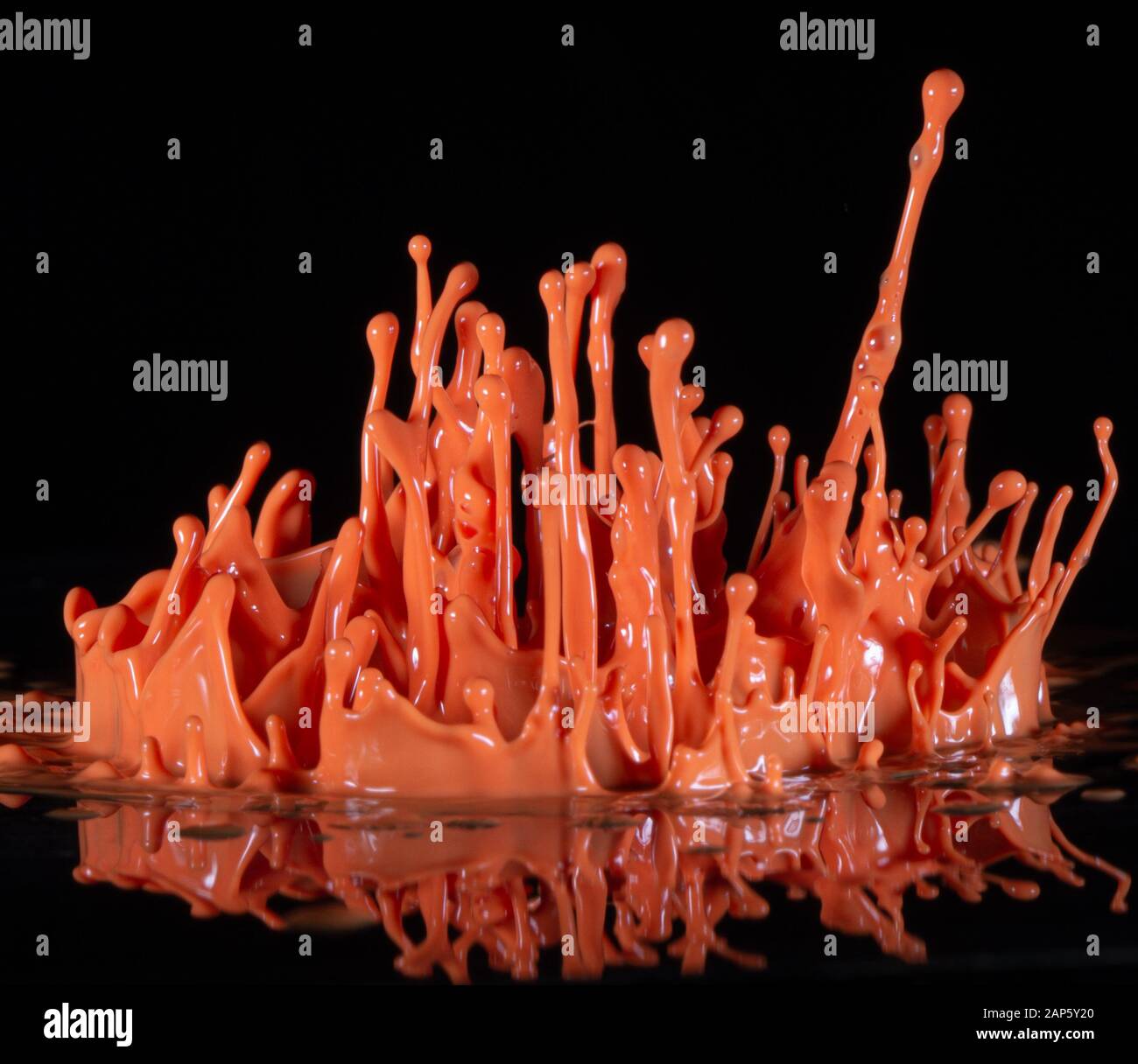 orange ink splash on a black background Stock Photo - Alamy