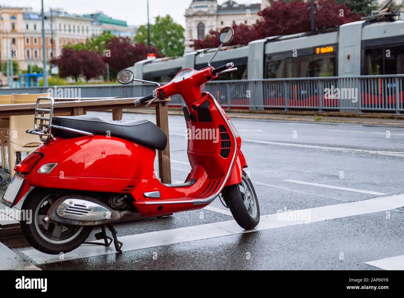 red stylish scooter at city street after rain Stock Photo - Alamy