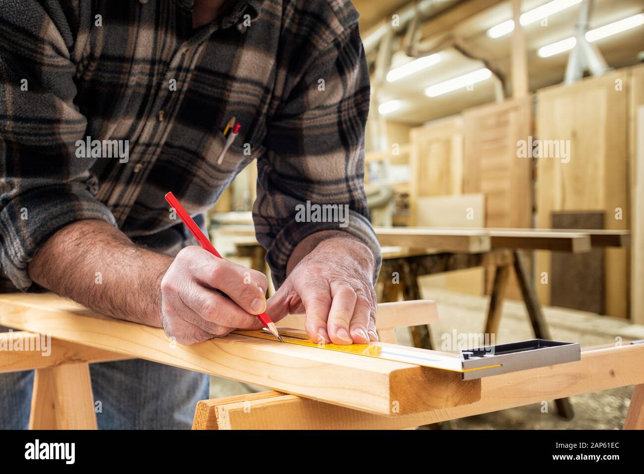 Close-up. Carpenter with pencil and carpenter's square draw the cutting ...