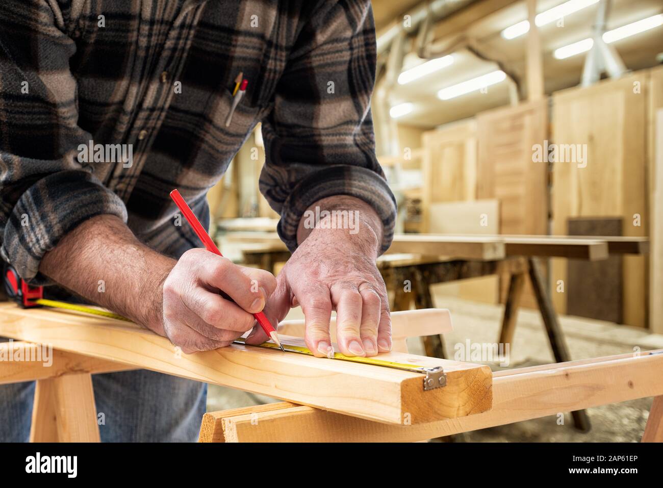 Close-up. Carpenter with pencil and the meter marks the measurement on ...