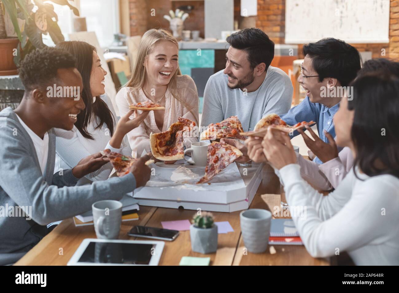 Happy people eating pizza at office during lunch time Stock Photo - Alamy