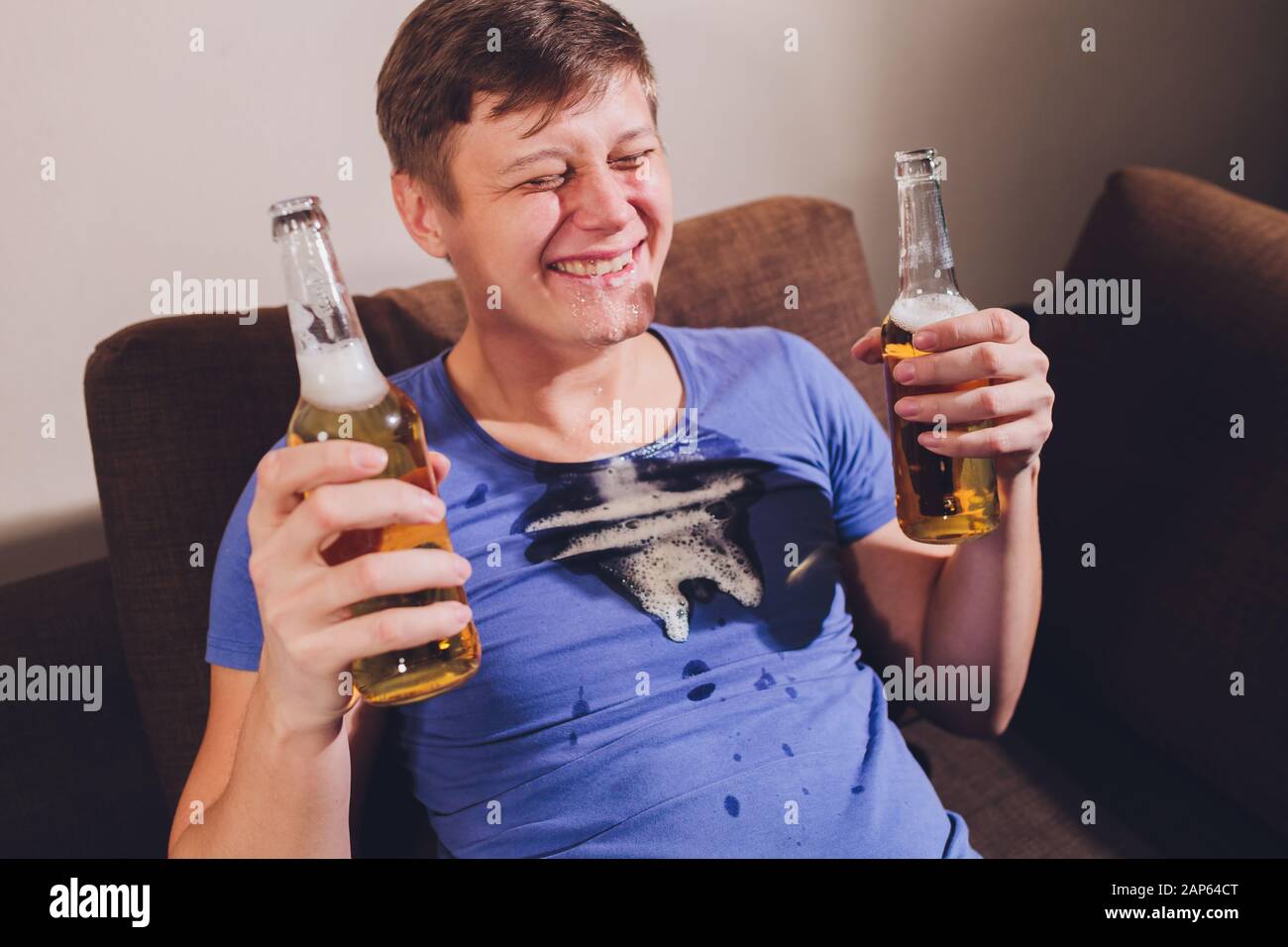 Alcoholism in the family. Beer bottle and spilled beer in the sofa ...