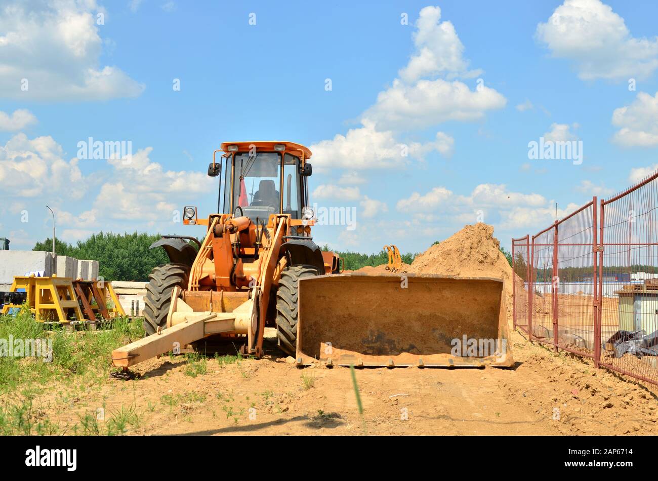 Wheel loader bulldozer with bucket on a construction site. Clearing the ...