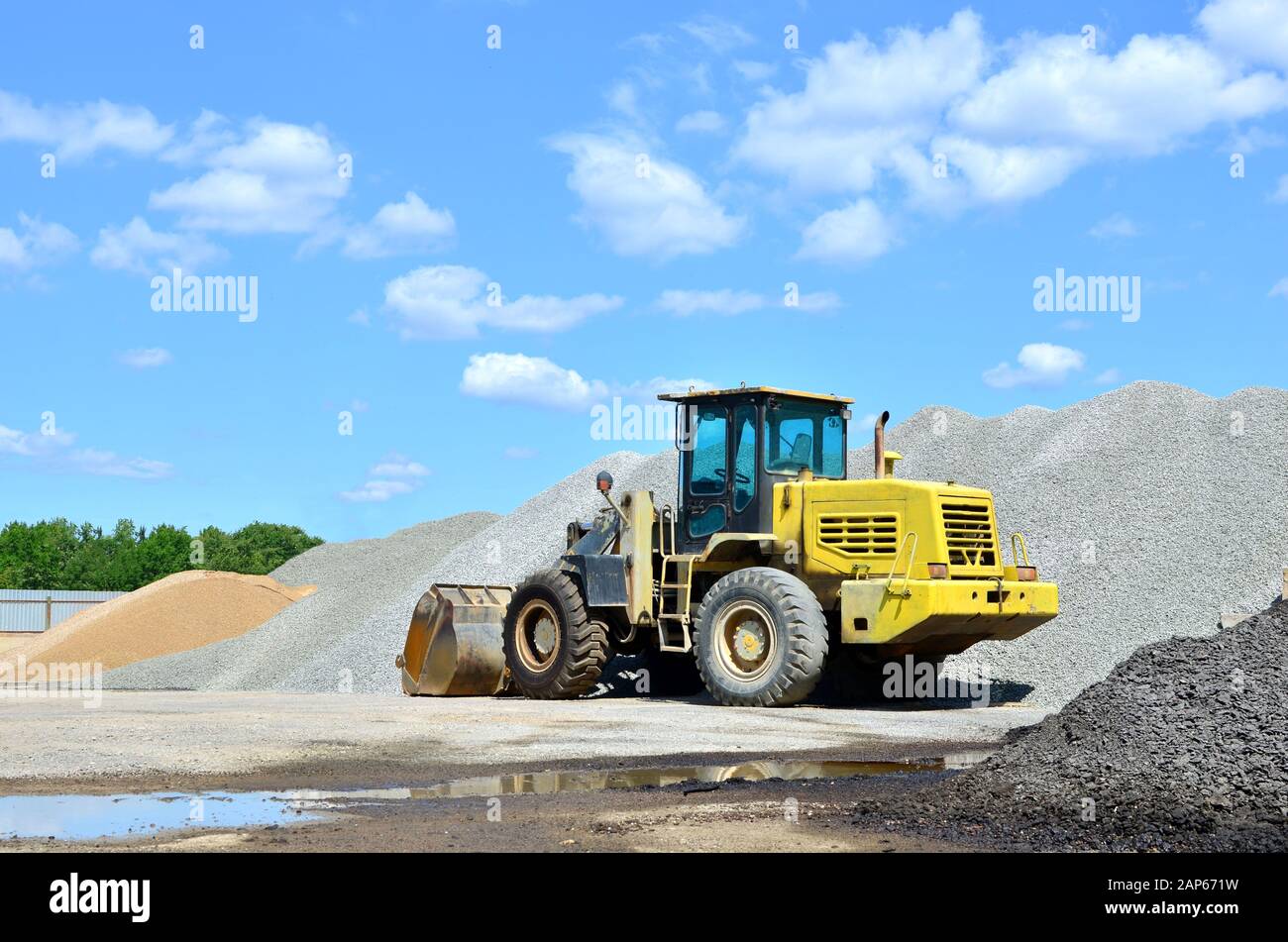 Yellow wheel loader on a cement production site. Loading of gravel ...