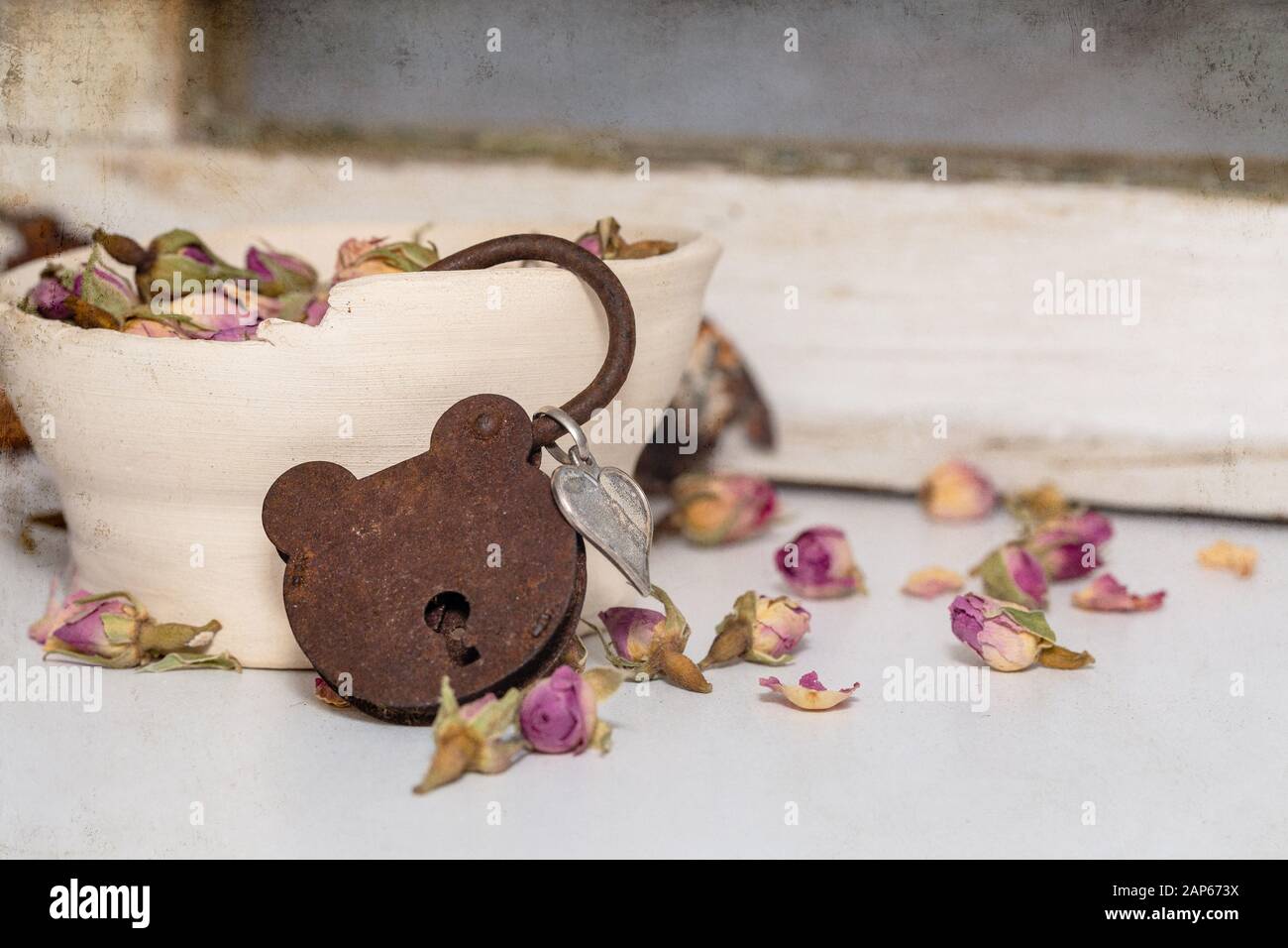 rusted teddy bear lock with dried roses, and ceramic bowl still-life ...