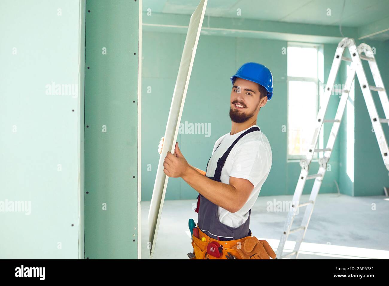 Worker builder installs plasterboard drywall at a construction Stock ...