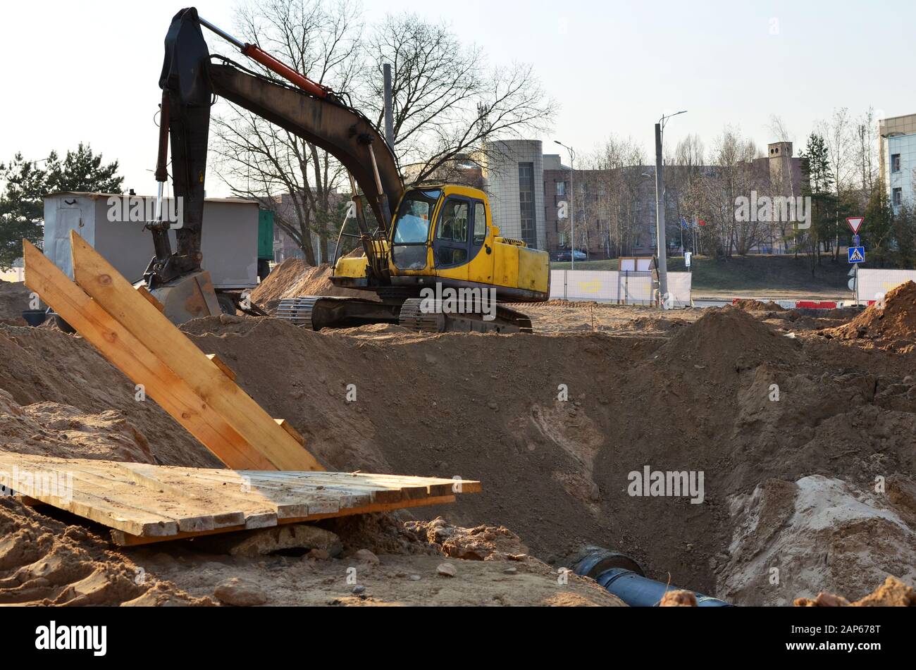 Tracked excavator working at a construction site during laying or ...