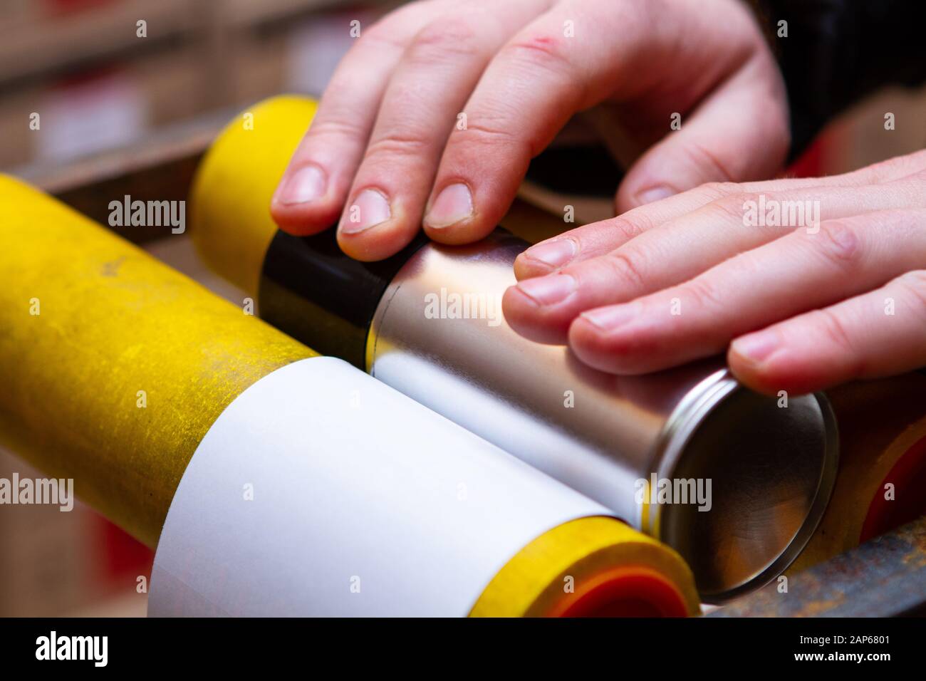manual application of stickers on aerosol cans with automotive and ...