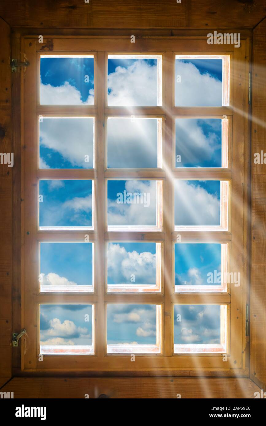 Wooden window with sunbeams shining from beautiful view to blue sky and ...