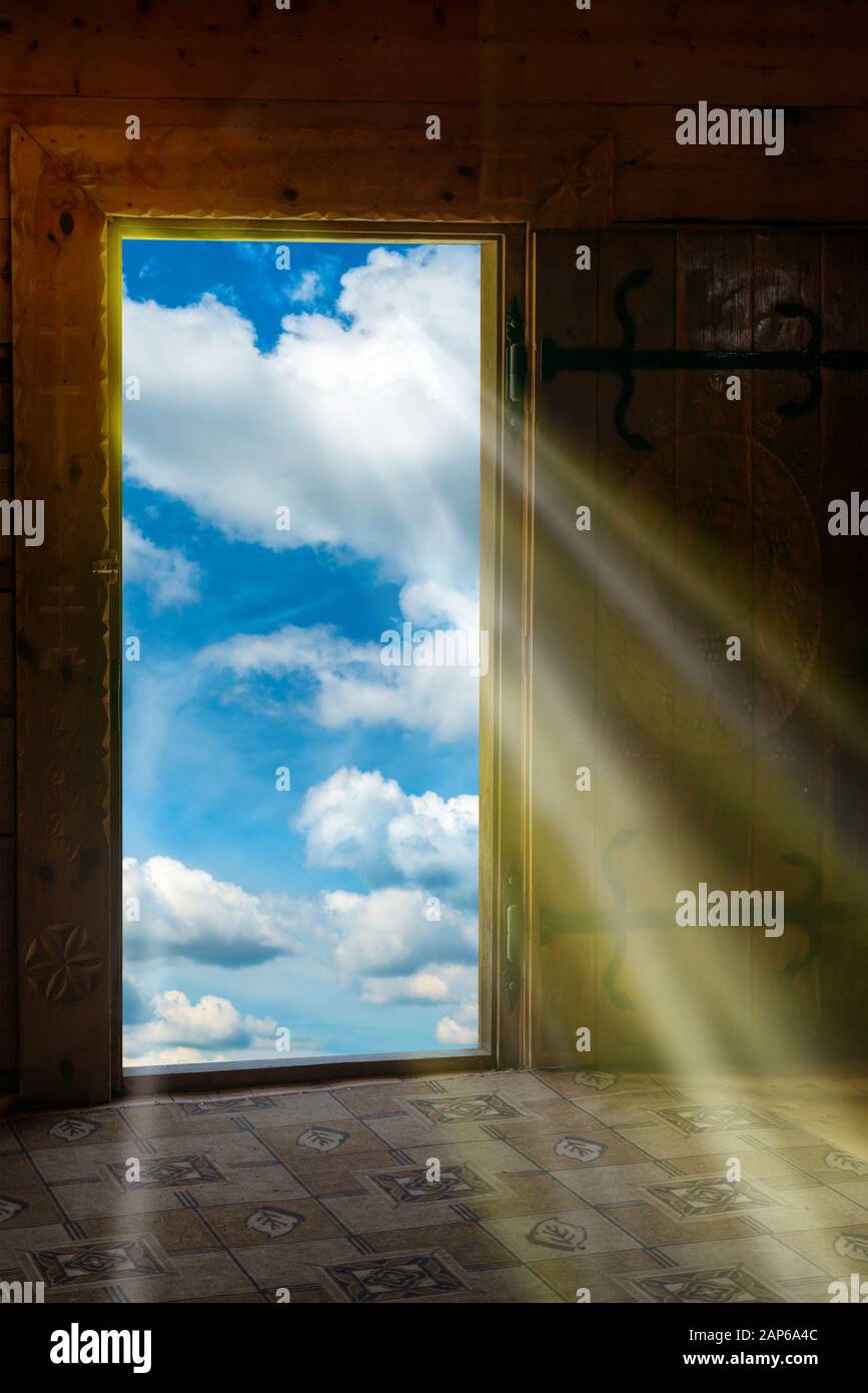 Sun light shining through wooden door from new world with blue sky and ...