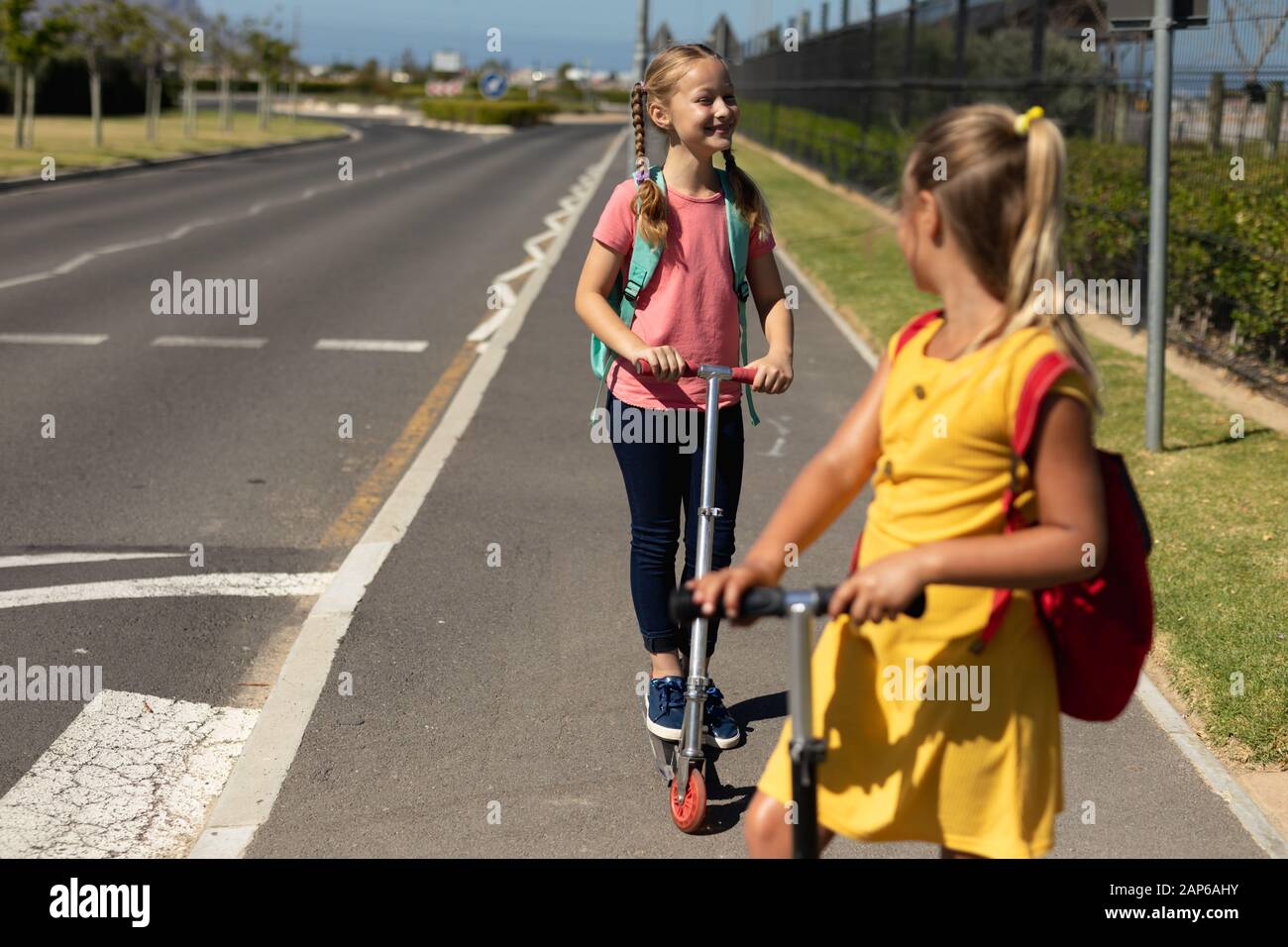 Caucasian schoolgirls riding push scooters Stock Photo - Alamy