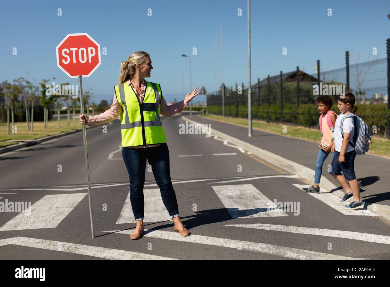 Woman wearing a high visibility vest and holding a stop sign Stock ...