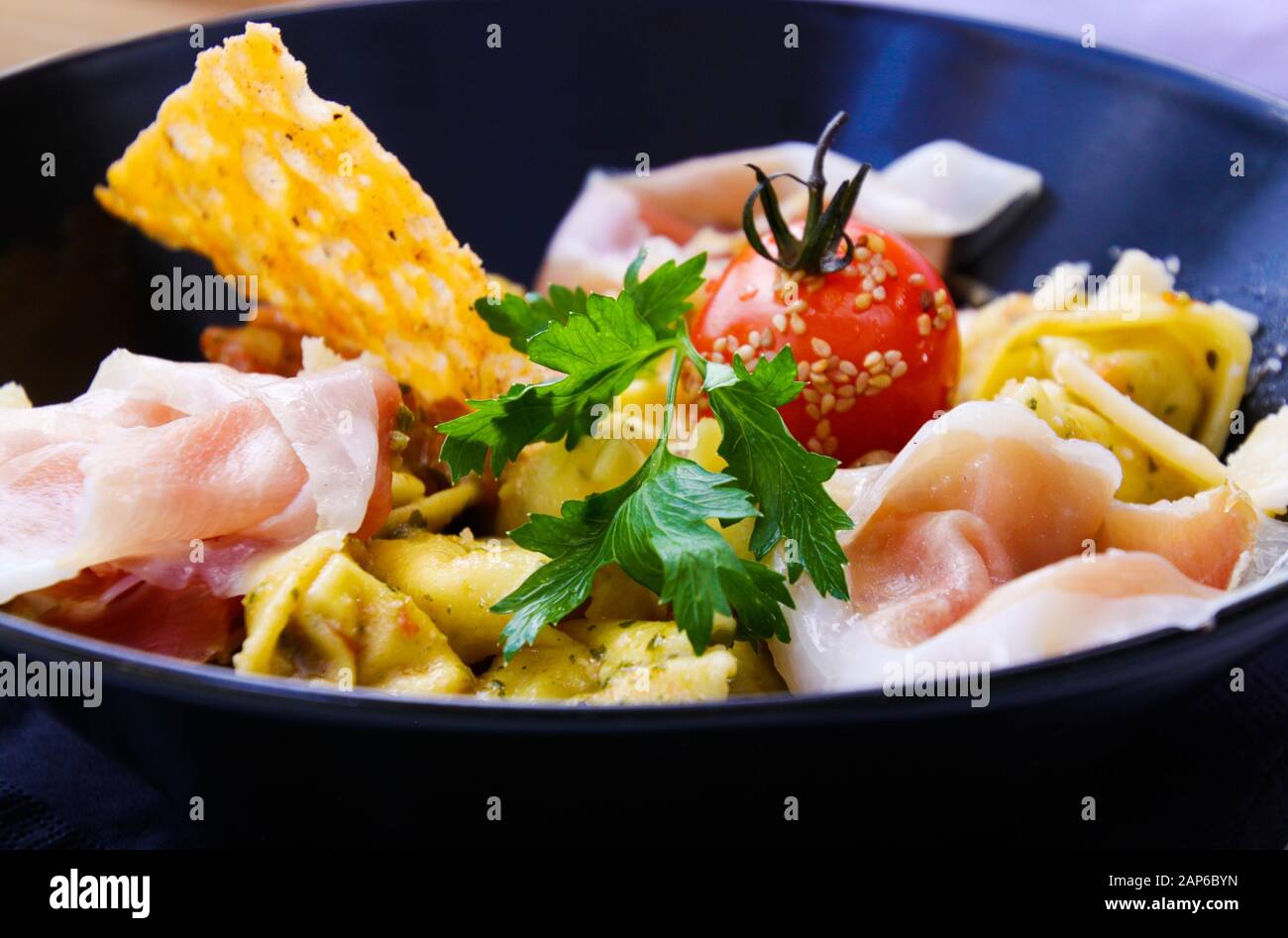 Close up of French pasta noodle dish with parsley leaf, fried cheese ...