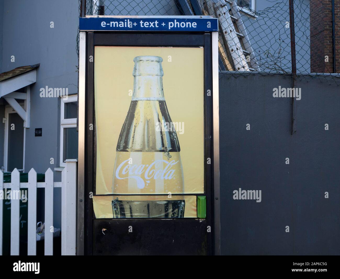 weather worn coca cola advertisement on BT phone box window Stock Photo ...