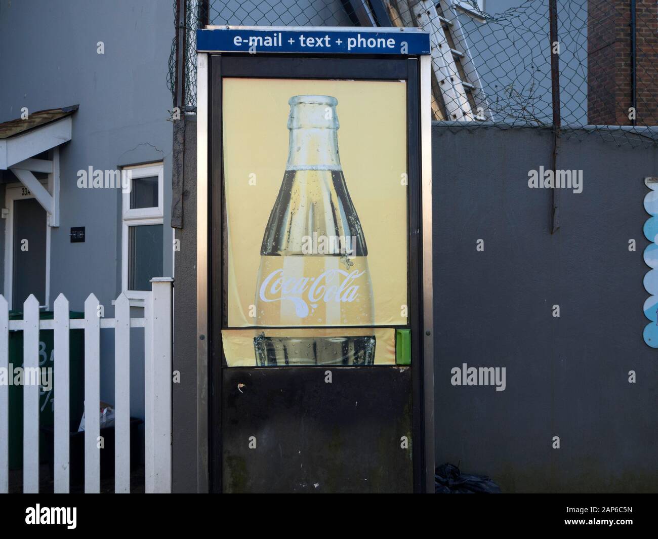 weather worn coca cola advertisement on BT phone box window Stock Photo ...