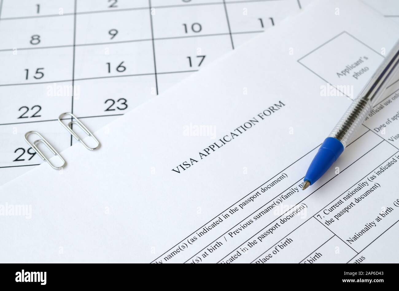 Typical Visa application form and blue pen on paper calendar page close ...