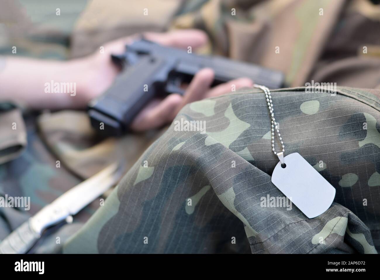 Army token lies on camouflage uniform of dead soldier and hand with ...