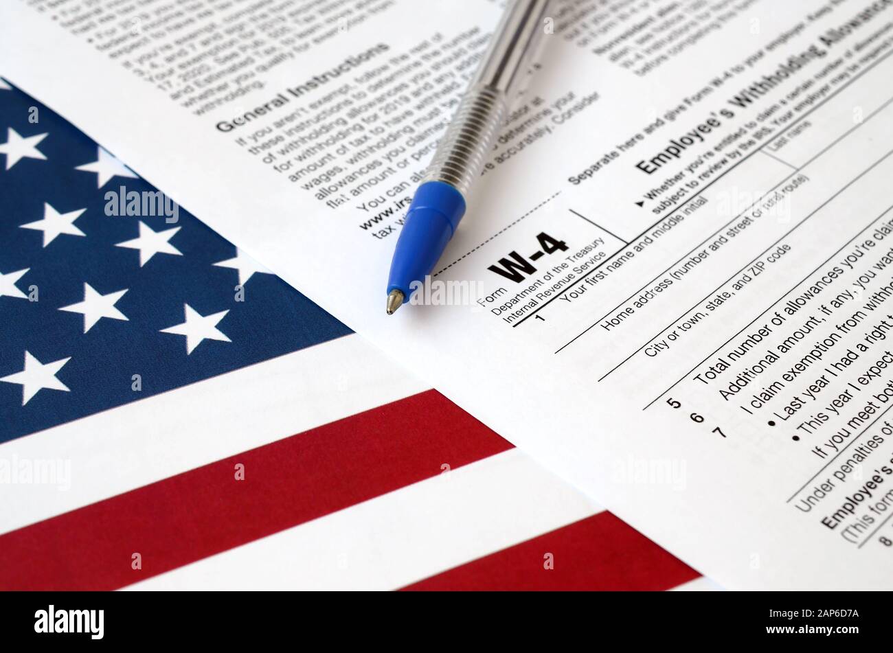 Form W-4 Employee's withholding allowance certificate and blue pen on ...