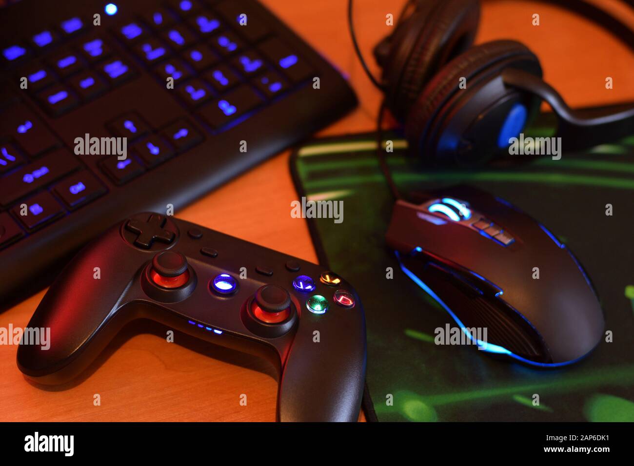 Modern gamepad and gaming mouse lies with keyboard and headphones on ...