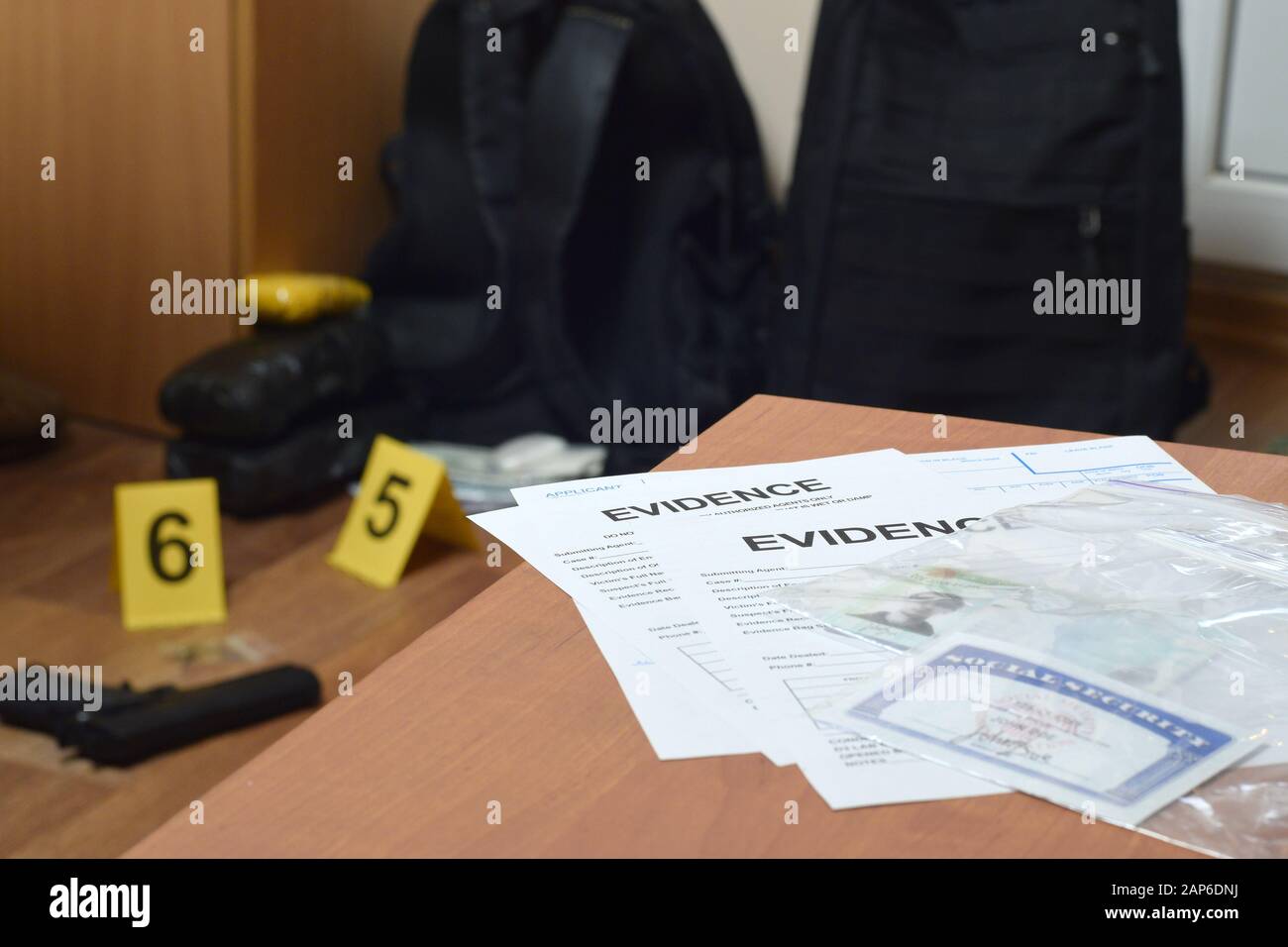 Evidence Labels and green card with ssn number lies on table with big ...