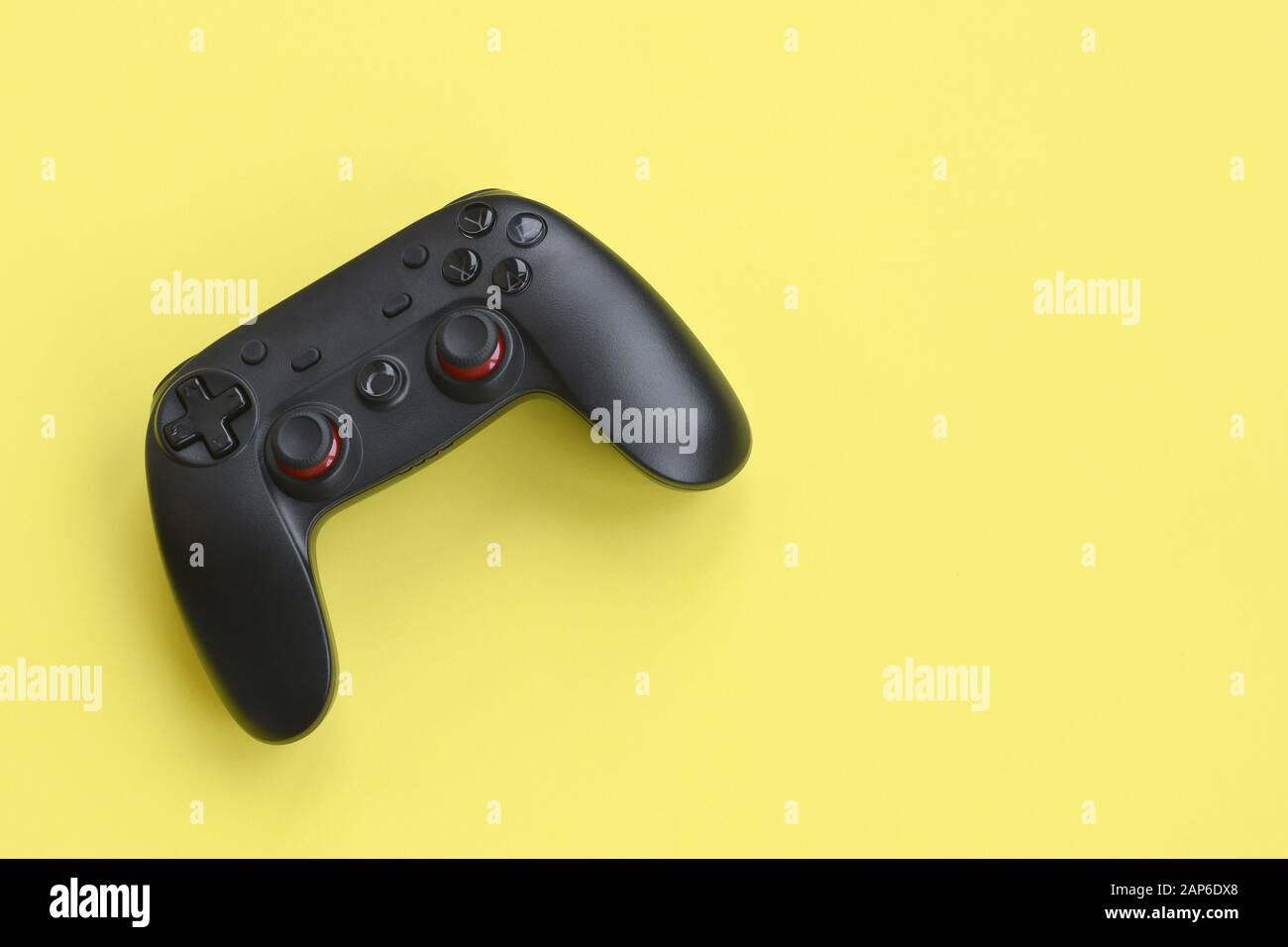 Modern black gamepad on yellow background close up. Esports and cyber ...