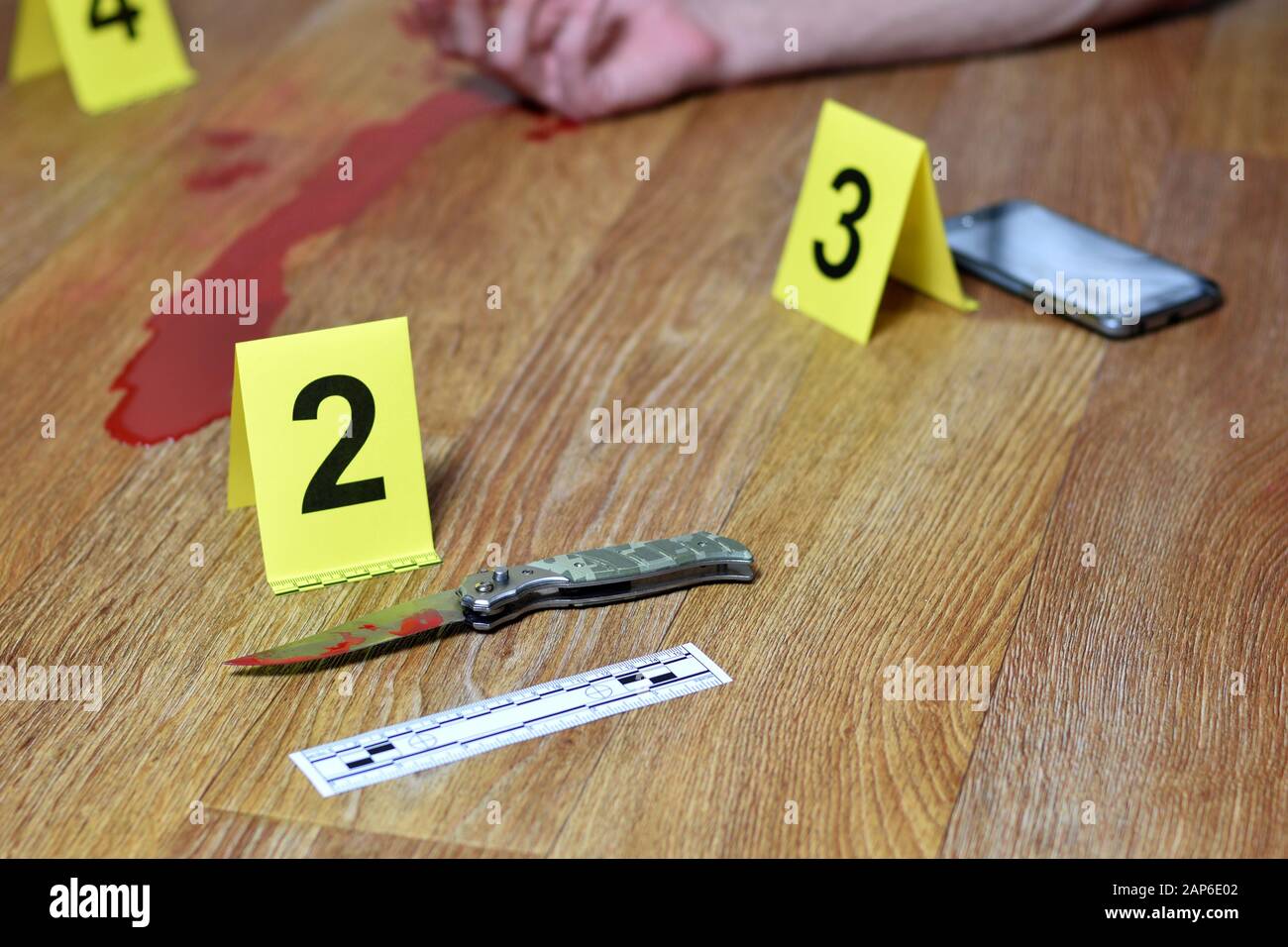 Crime scene investigation - Bloody knife and victims hand with yellow ...
