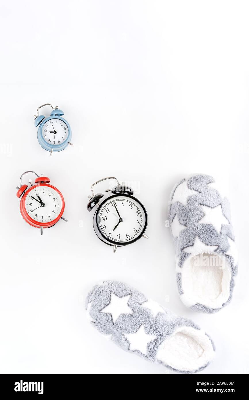Sleep. Soft fluffy slippers and set of alarm clocks isolated on white ...