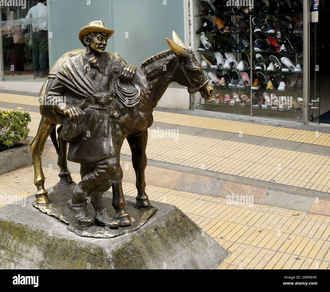 Bronze sculpture of drover with donkey on pedestrian shopping street in ...