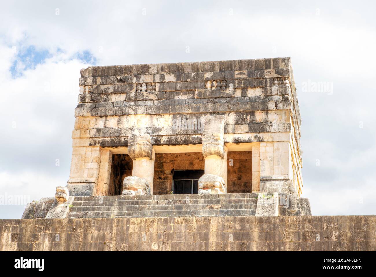 Mayan temple with intricate carvings above the ancient ball game court ...