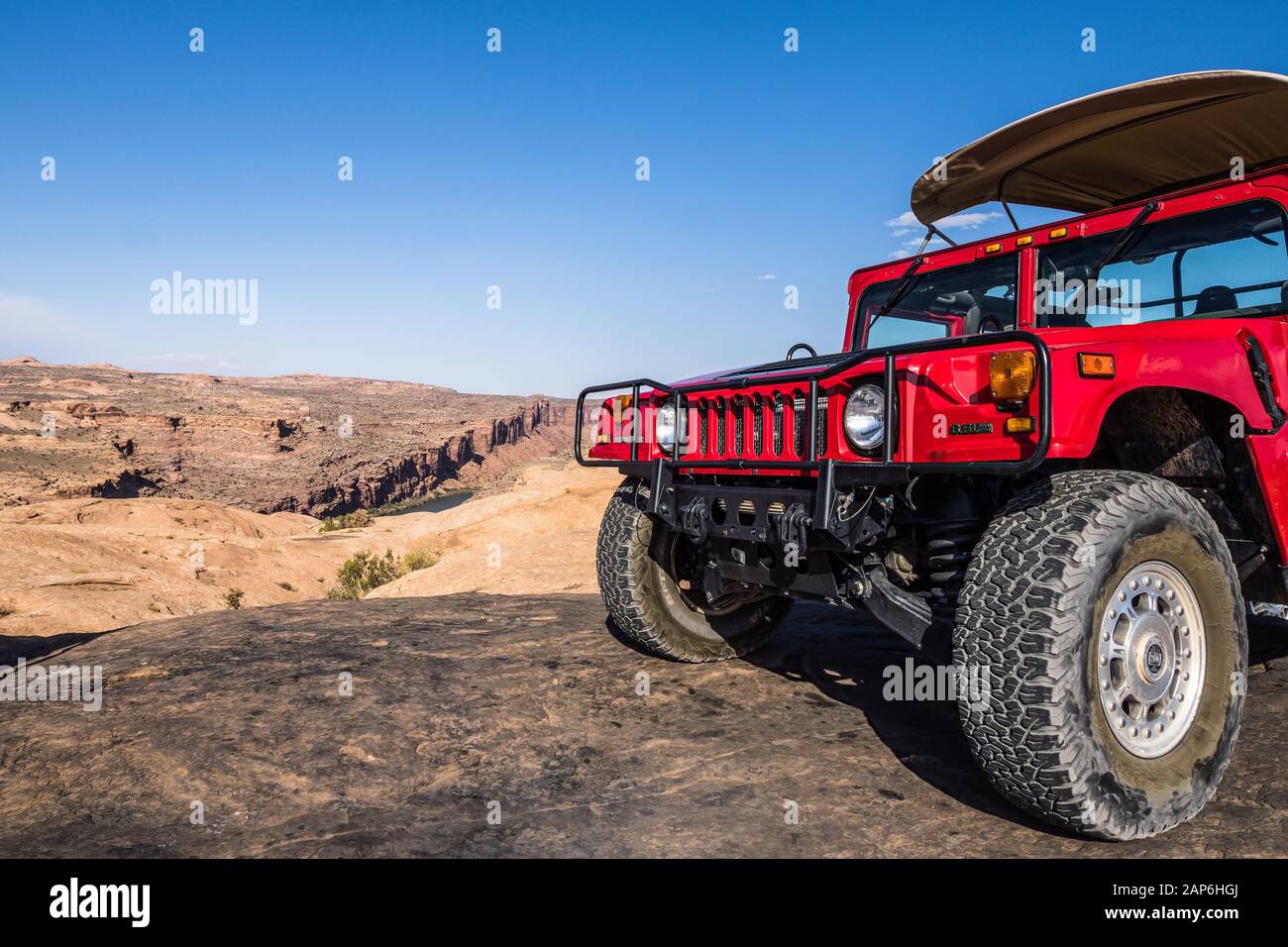 An H1 Hummer parked on a sandstone hilltop over looking the Colorado ...