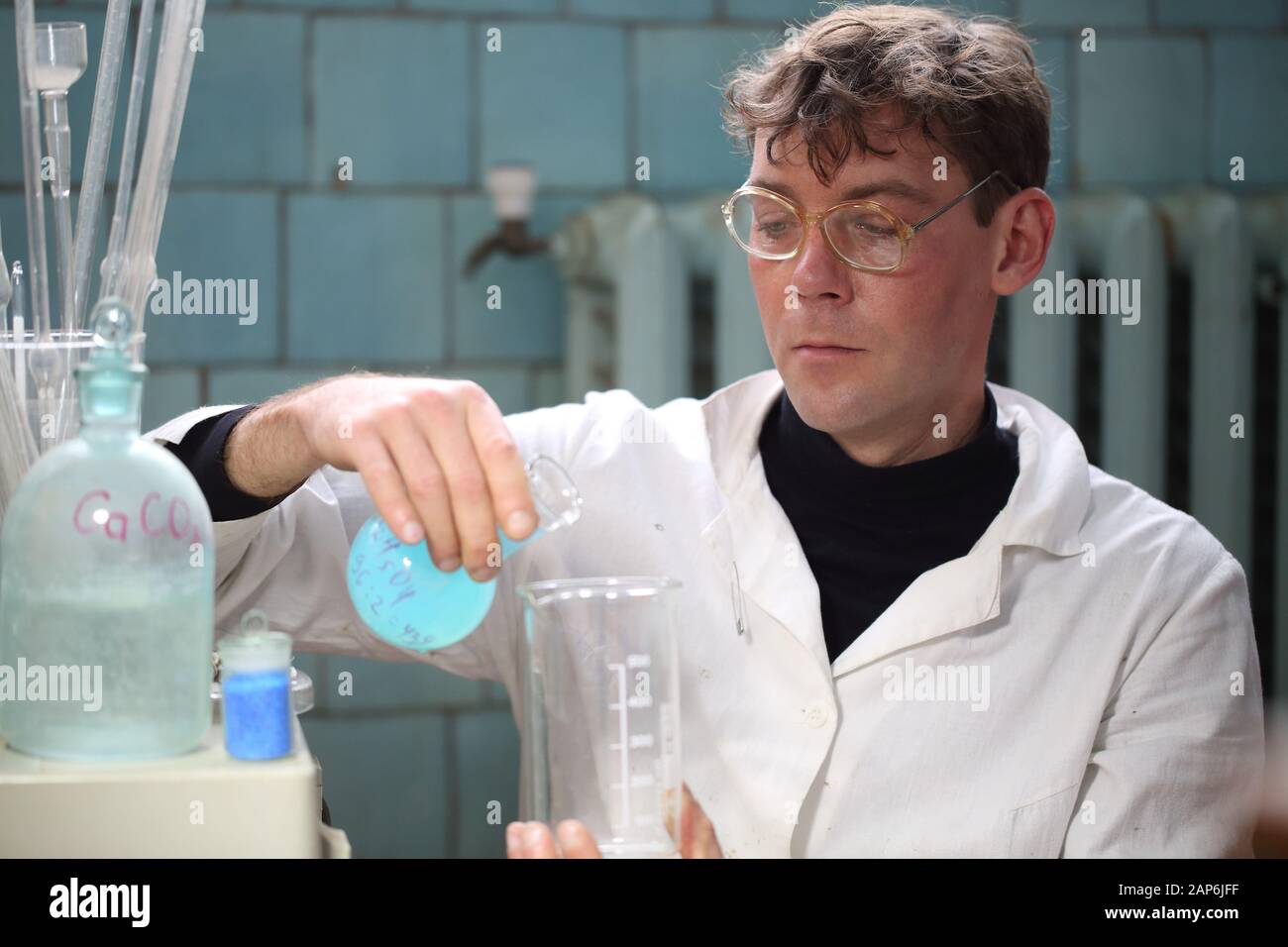 A scientist in a laboratory pours a reagent into a measuring cup Stock ...
