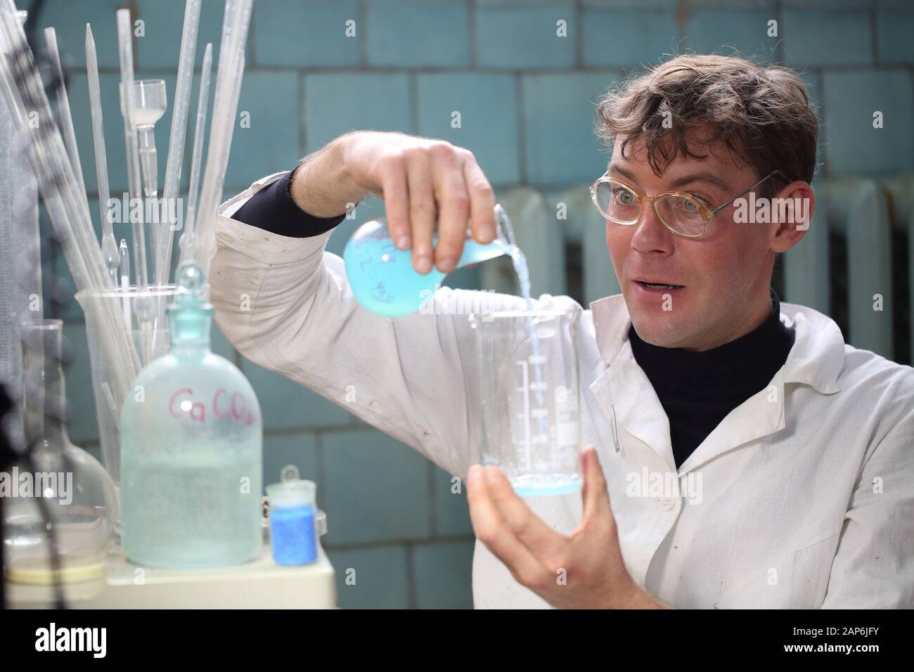 A scientist in a laboratory pours a reagent into a measuring cup Stock ...