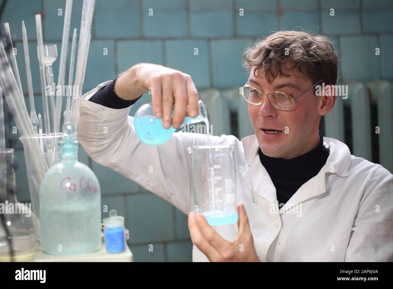 A scientist in a laboratory pours a reagent into a measuring cup Stock ...