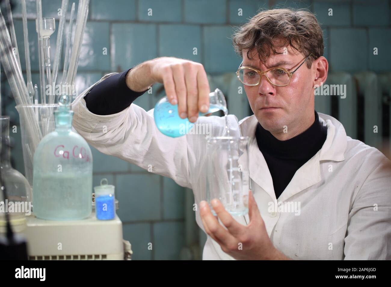 A scientist in a laboratory pours a reagent into a measuring cup Stock ...