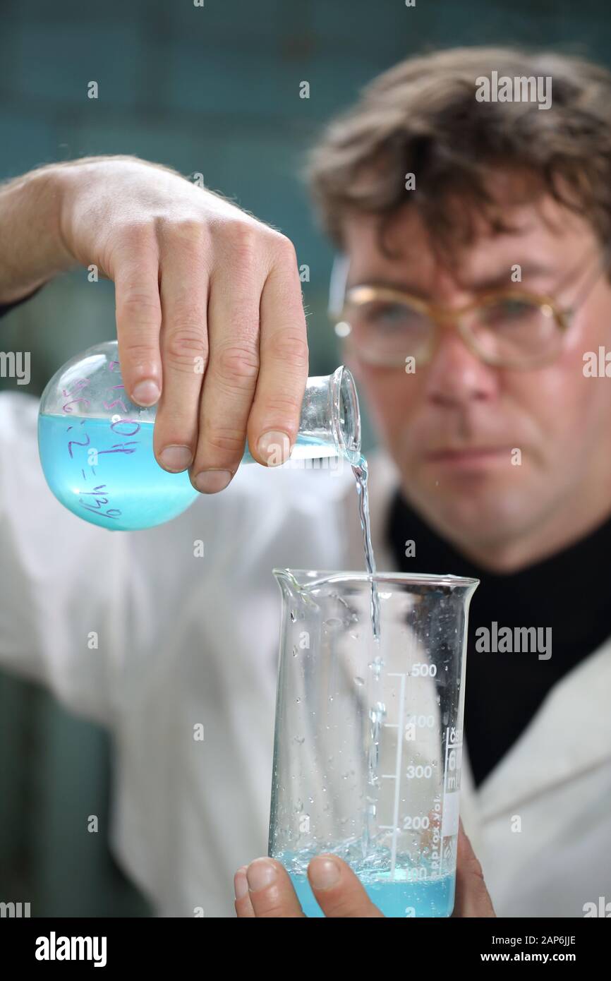 A scientist in a laboratory pours a reagent into a measuring cup Stock ...