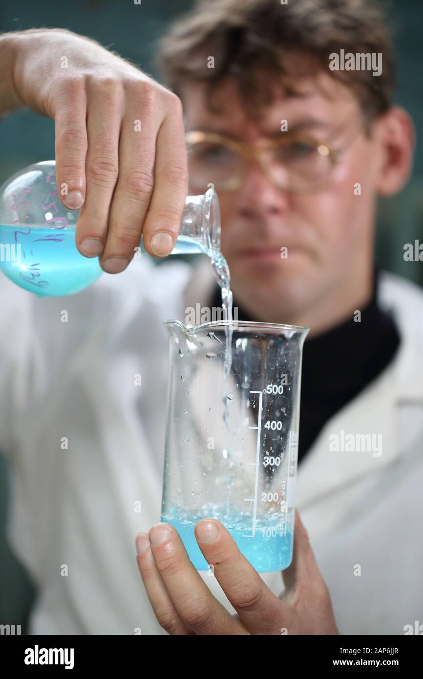 A scientist in a laboratory pours a reagent into a measuring cup Stock ...