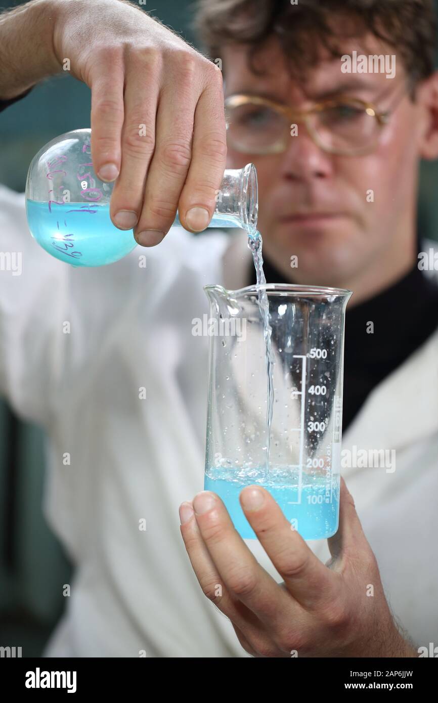 A scientist in a laboratory pours a reagent into a measuring cup Stock ...