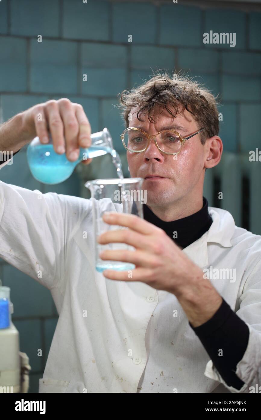 A scientist in a laboratory pours a reagent into a measuring cup Stock ...