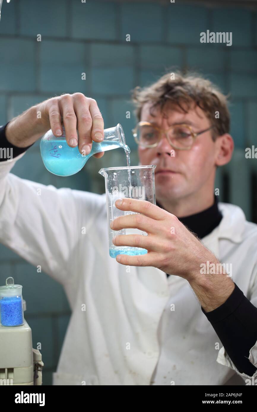 A scientist in a laboratory pours a reagent into a measuring cup Stock ...