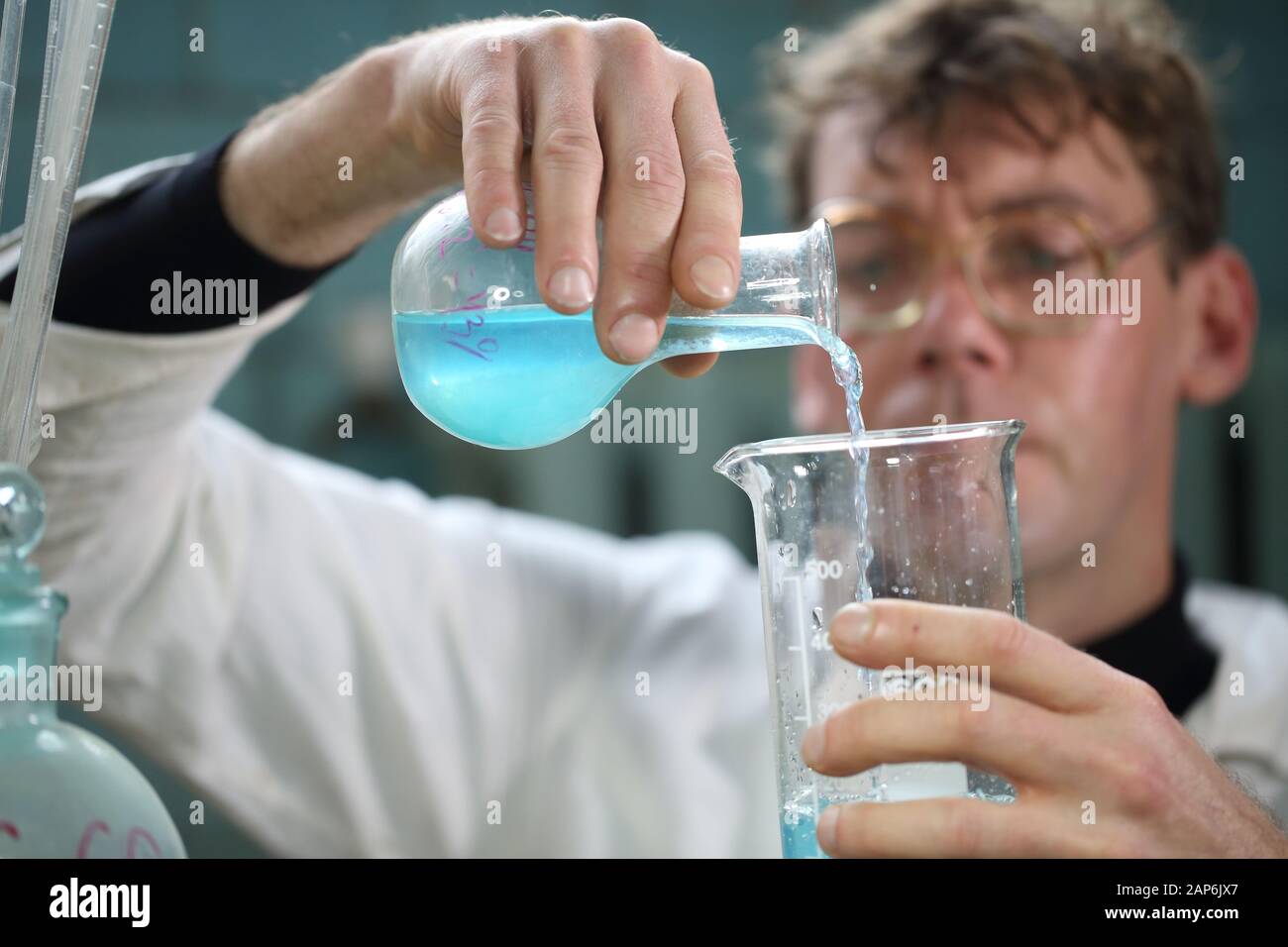 A scientist in a laboratory pours a reagent into a measuring cup Stock ...